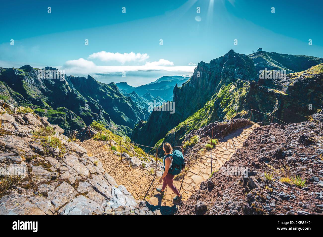 Description: Woman with backpack hiking along very scenic hike trail to ...