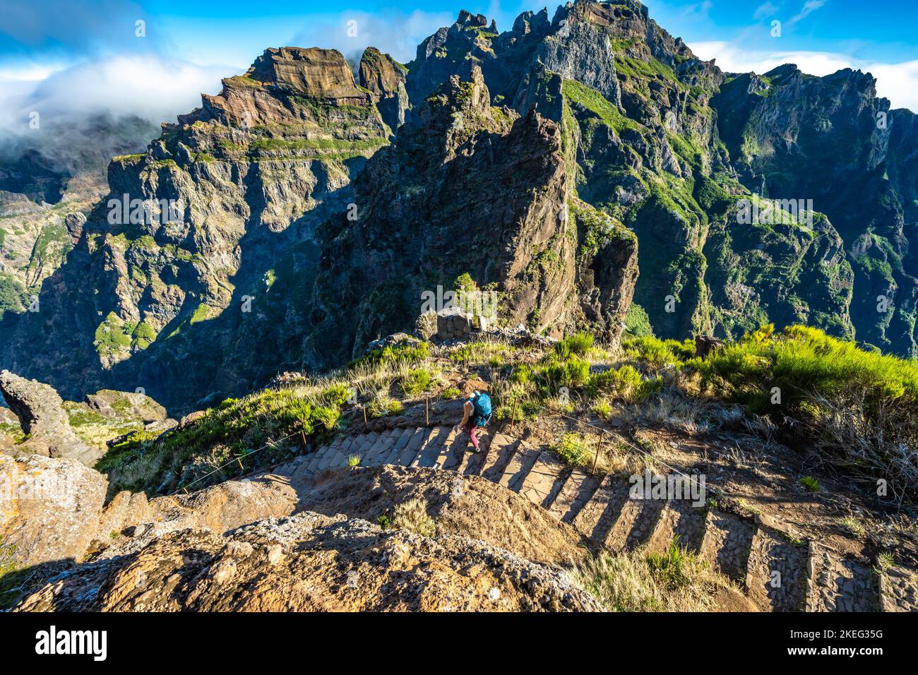 Description: Woman with backpack hiking down steep stairs along very ...