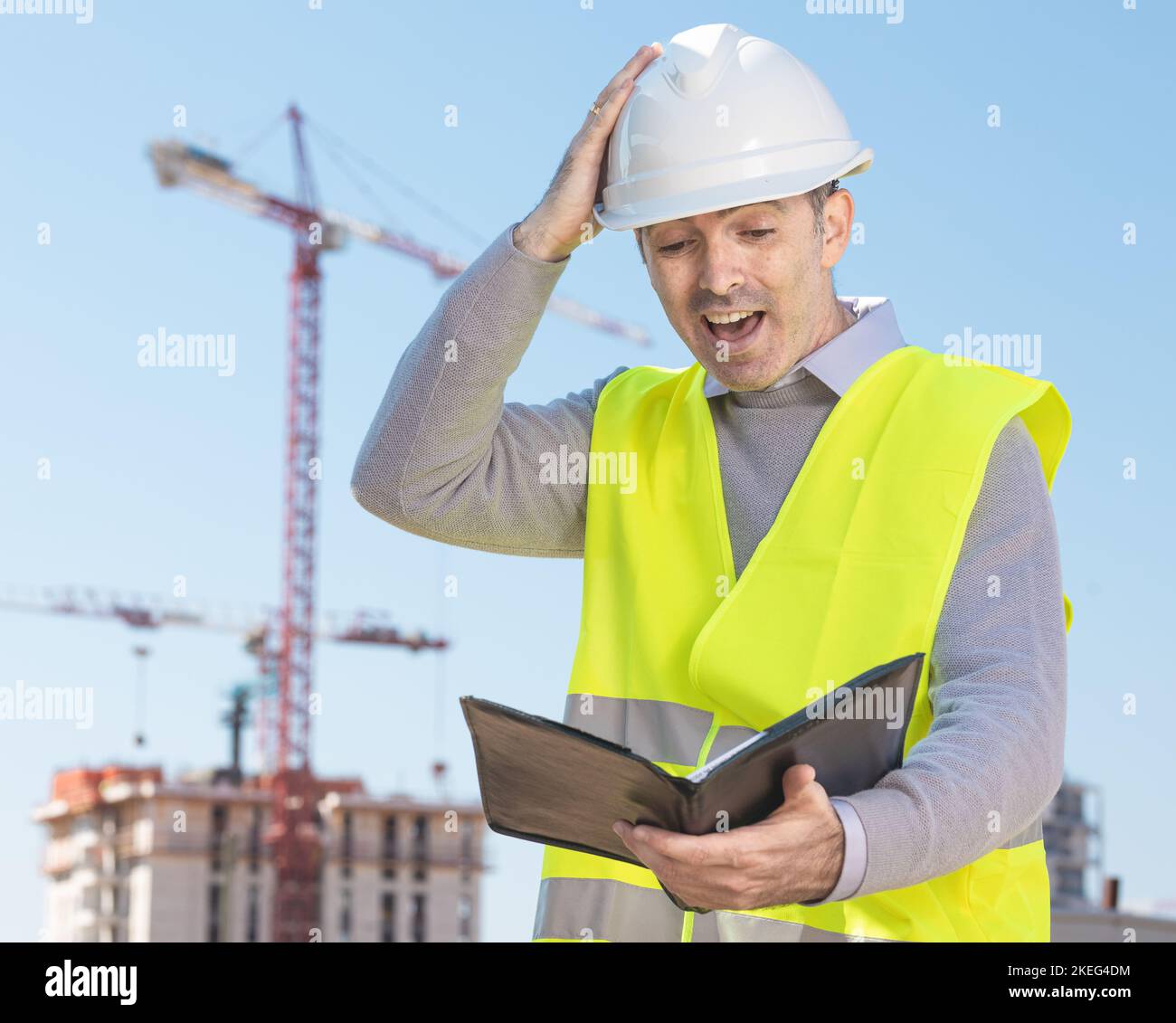 Professional builder standing with a notebook in front of the ...