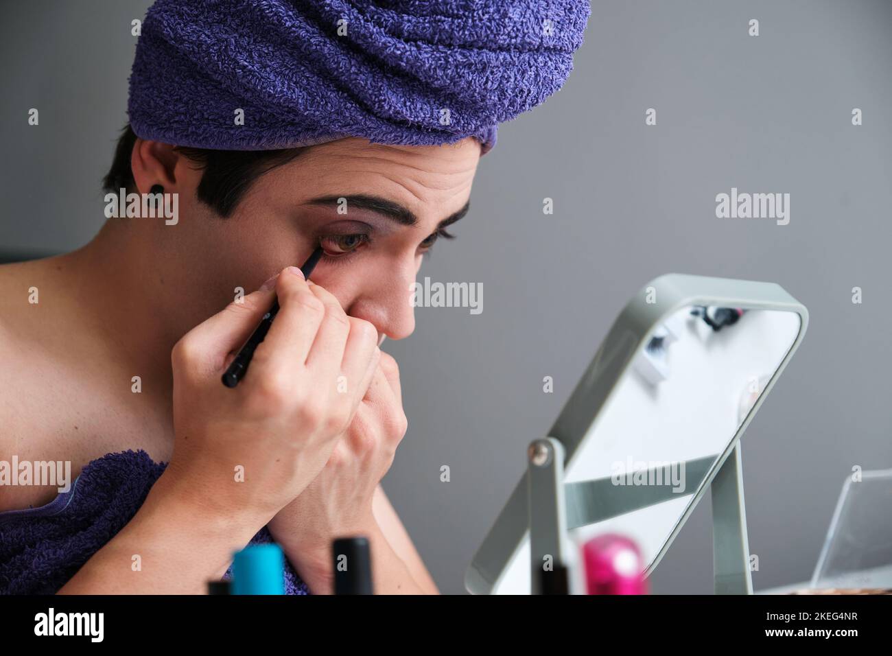 Young transgender man applying eyeliner Stock Photo - Alamy
