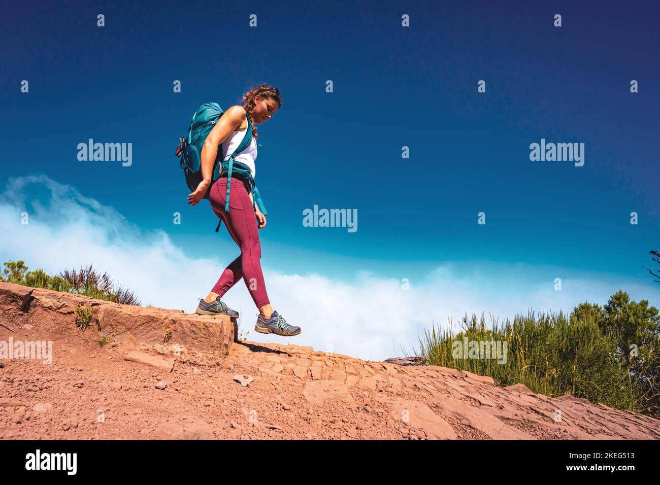 Description: Hiker with backpack walking down a step along the hiking ...