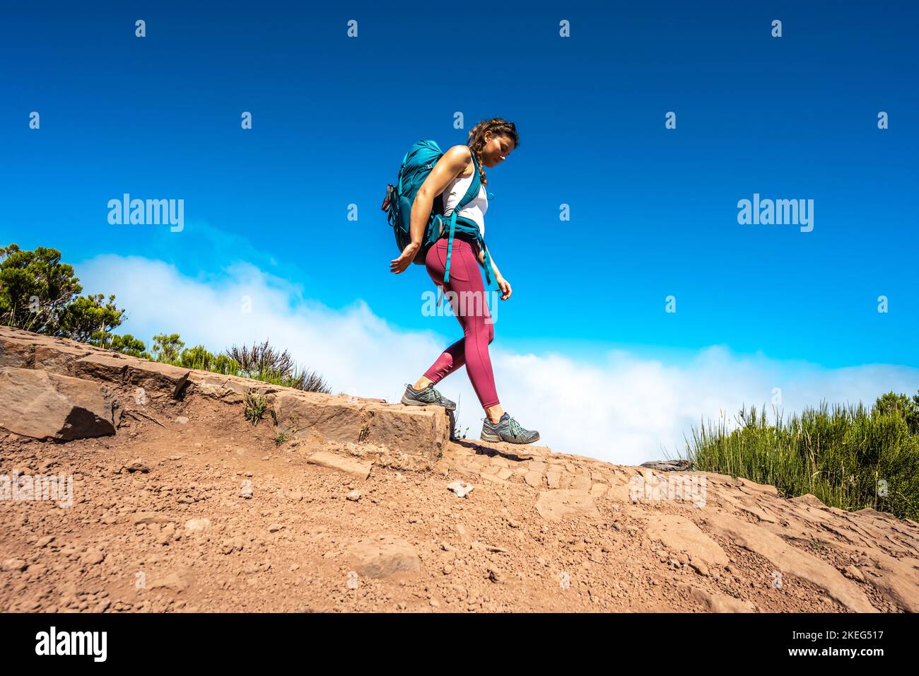 Description: Hiker with backpack walking down a step along the hiking ...