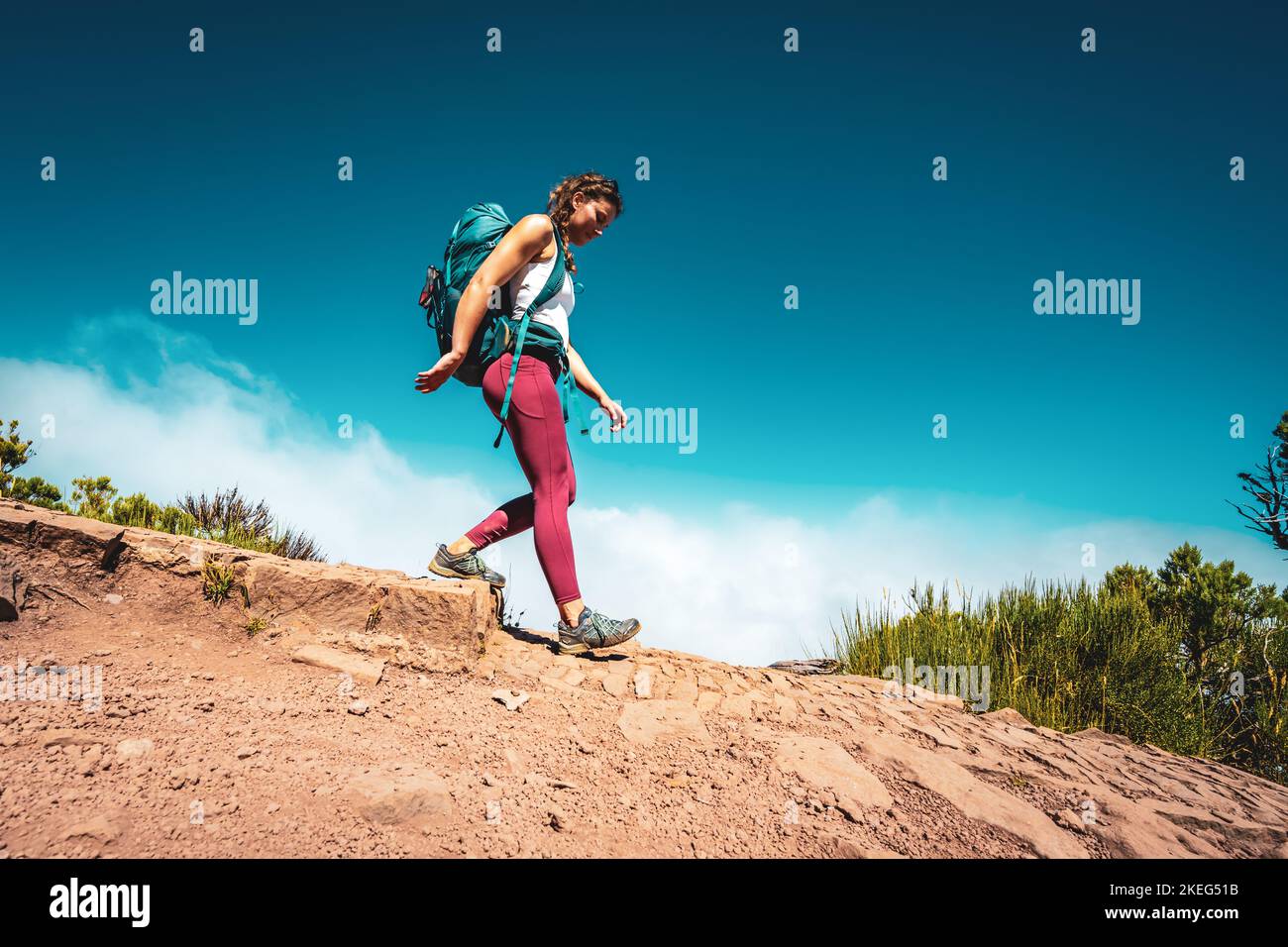 Description: Hiker with backpack walking down a step along the hiking ...