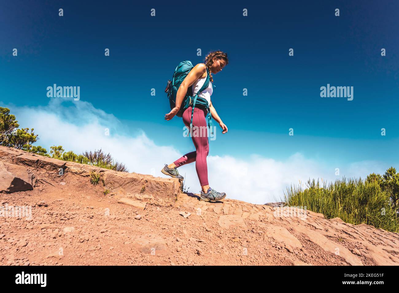 Description: Hiker with backpack walking down a step along the hiking ...