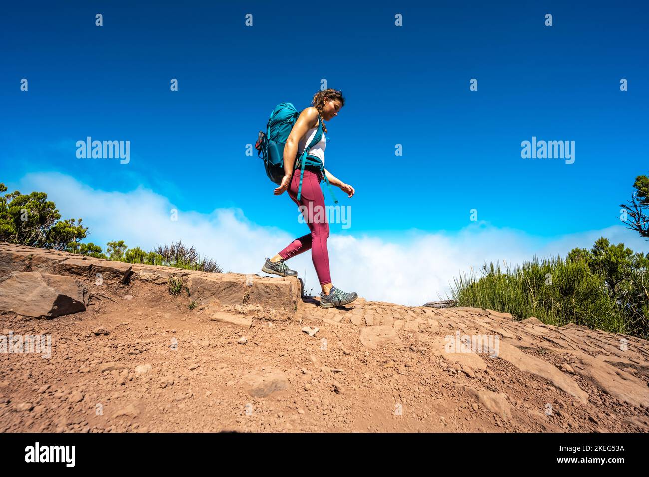 Description: Hiker with backpack walking down a step along the hiking ...
