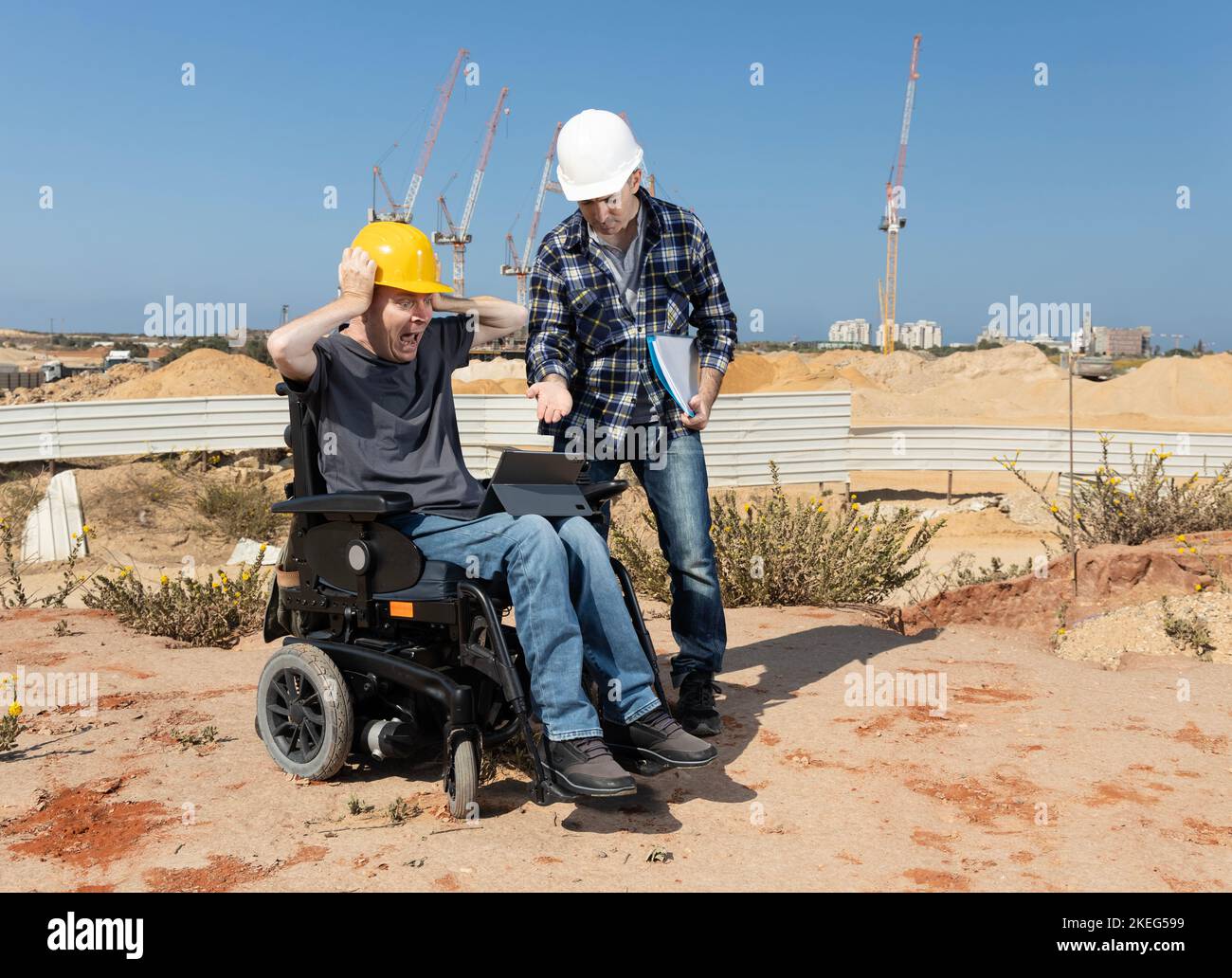 Two professional builders standing with a computer in front of the ...