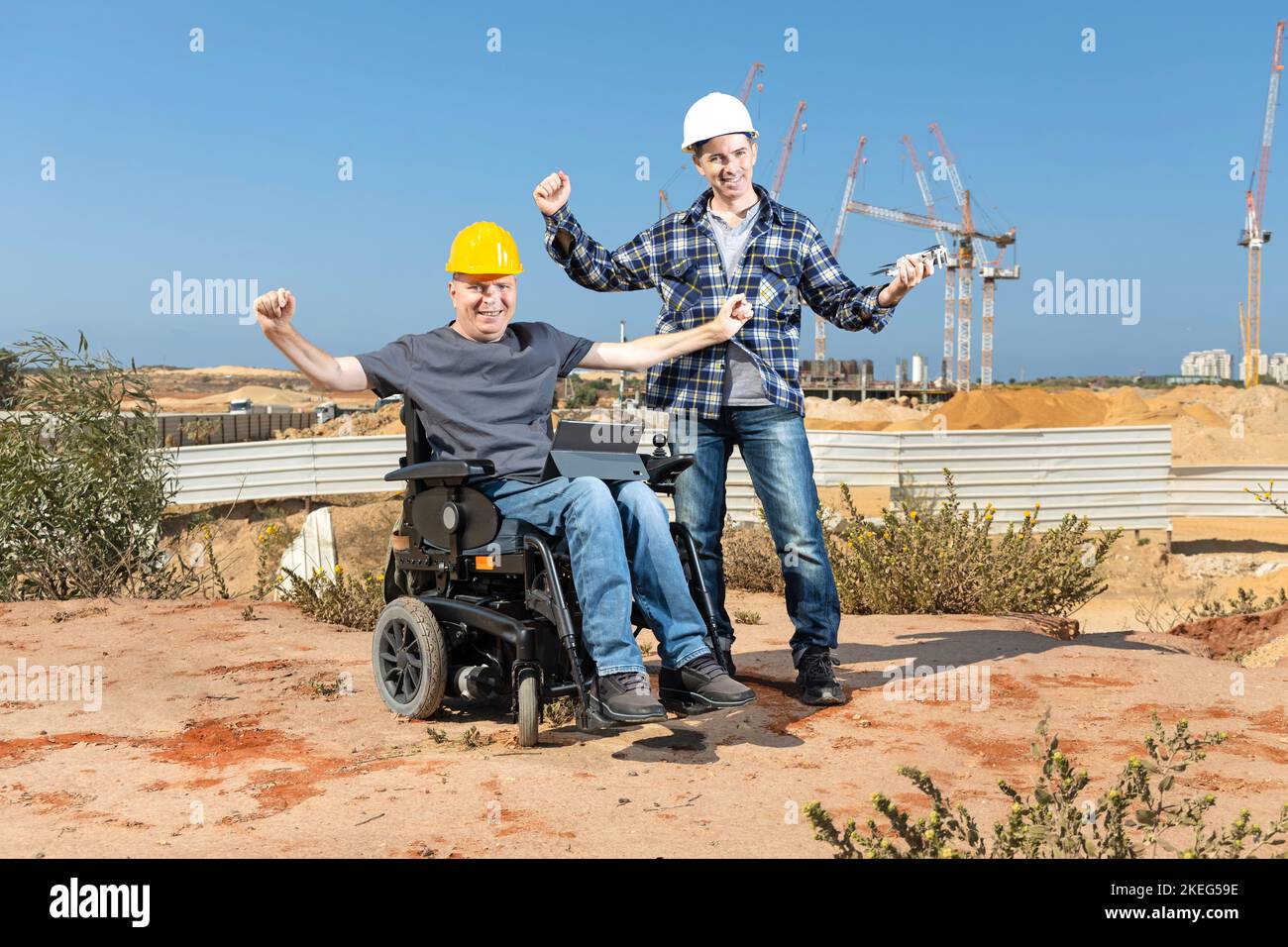 Two professional builders standing with a computer in front of the ...