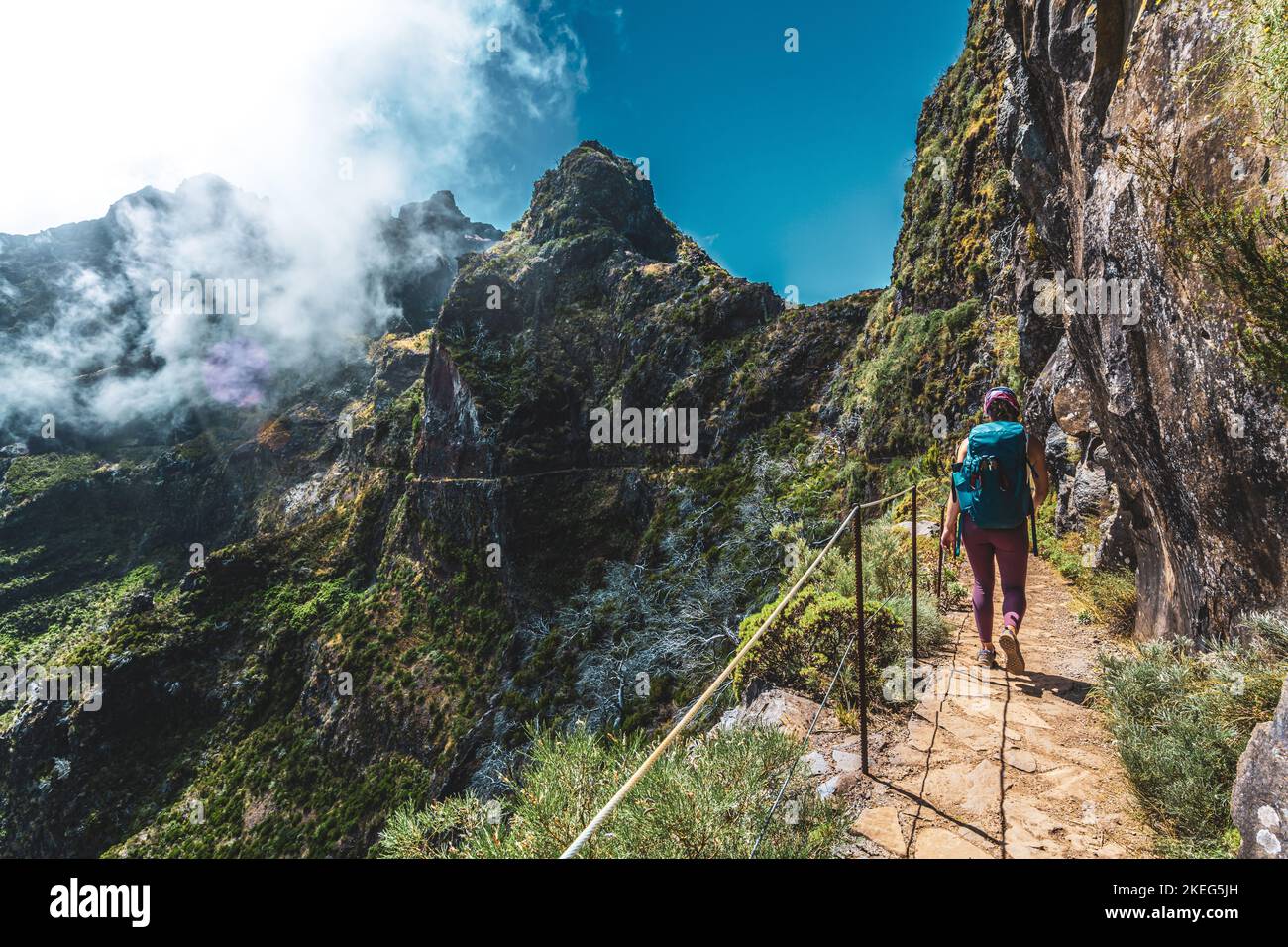 Description: Hiker with backpack walking along very scenic hike trail ...