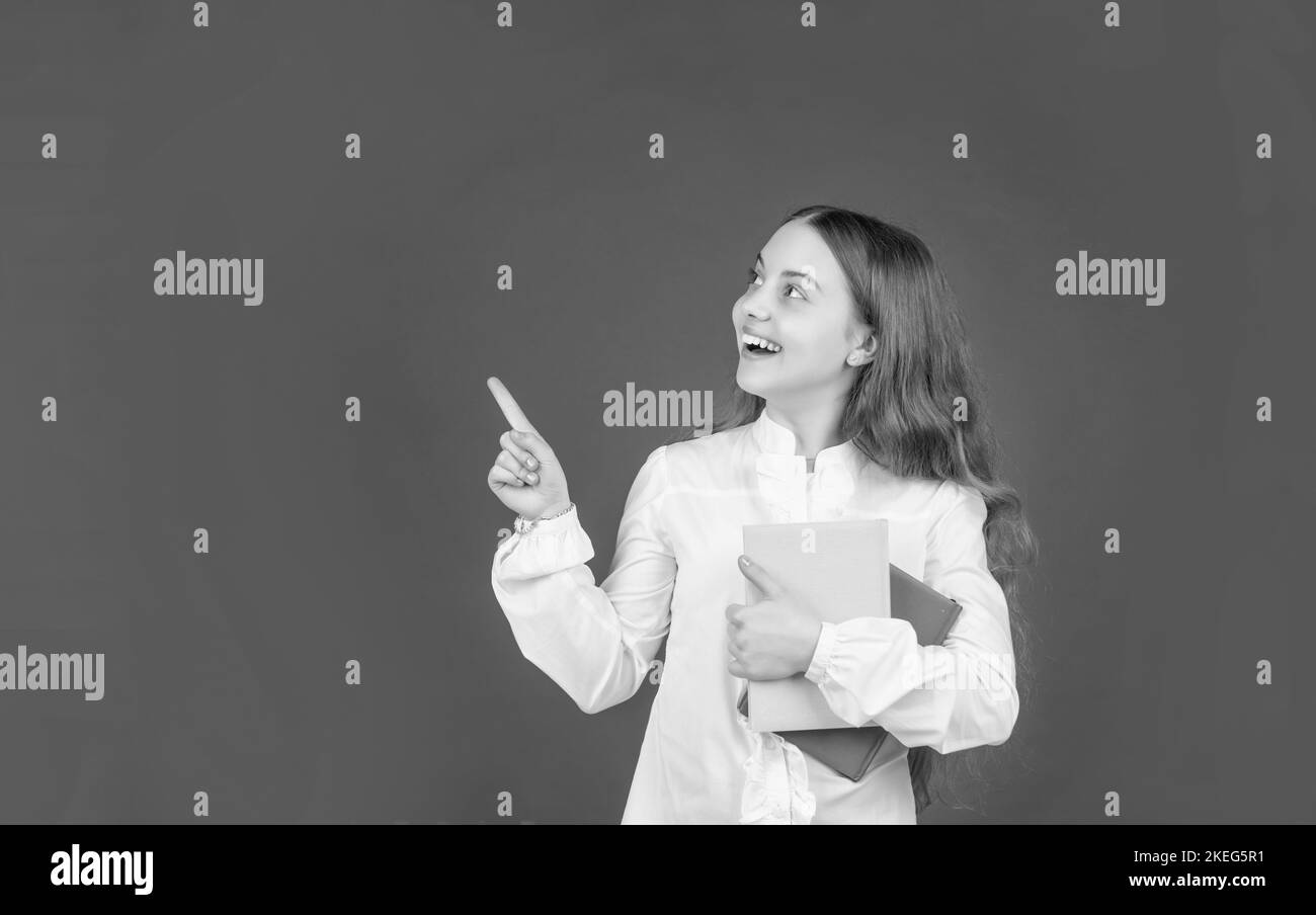 child going to do homework with book. teenager student point finger on ...