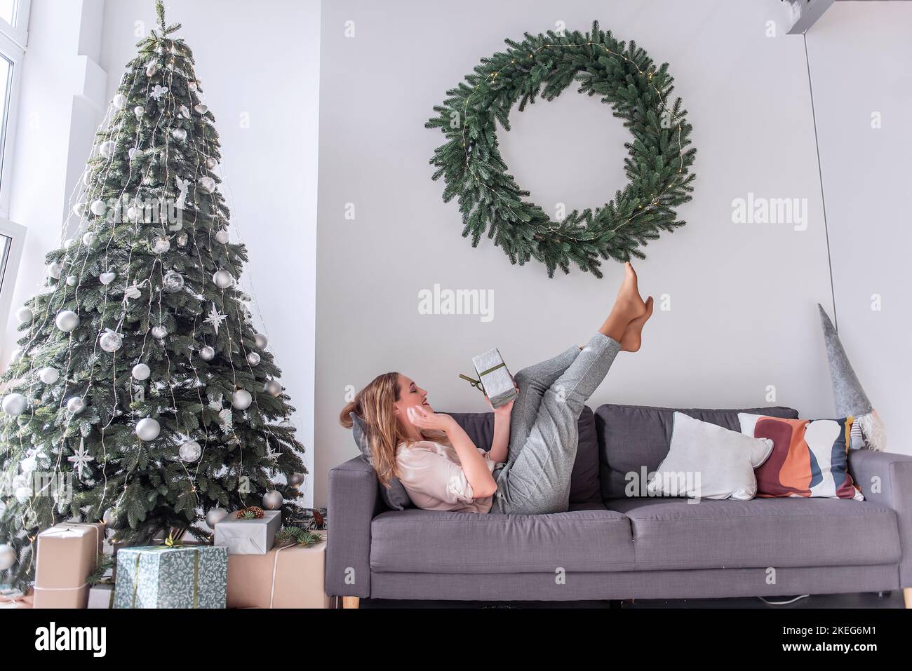 Millennial woman with red lipstick in pin-up style, holding a gift in ...