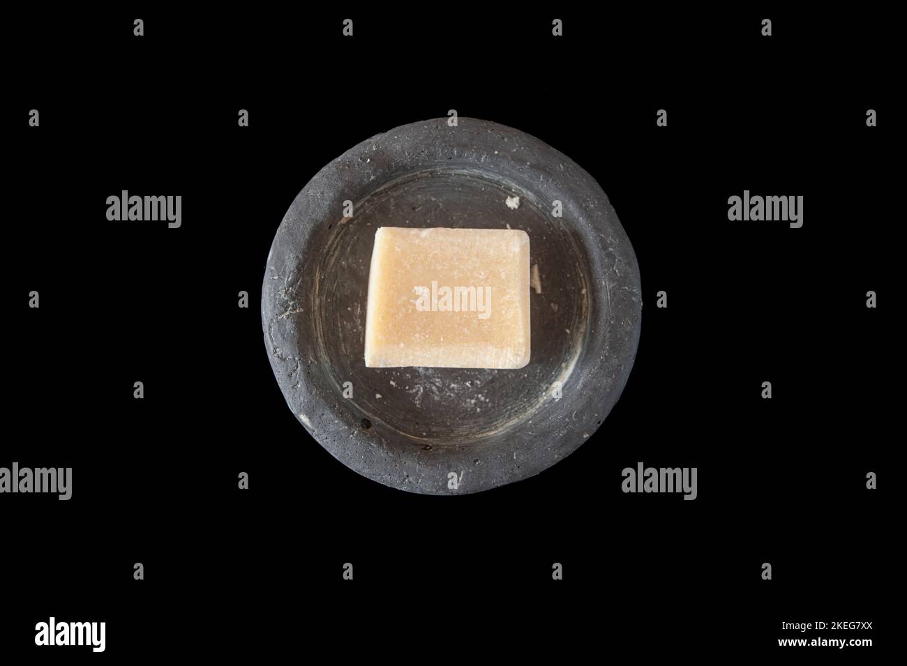 A top view of a smelling block in a stone cup isolated on the black ...