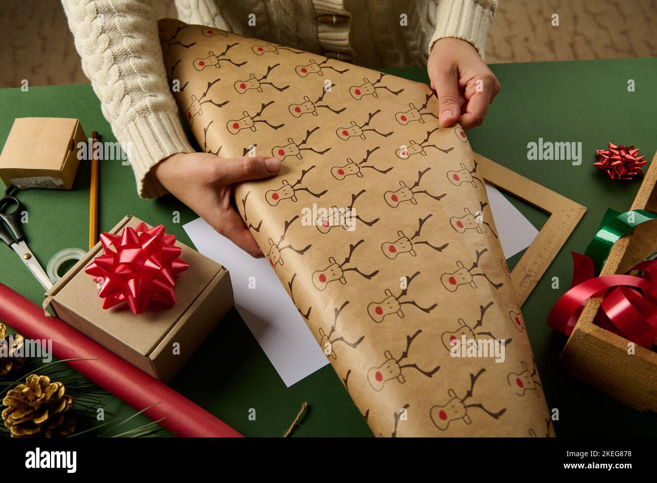 Details: woman's hands rolling out a wrapping paper with deer pattern ...