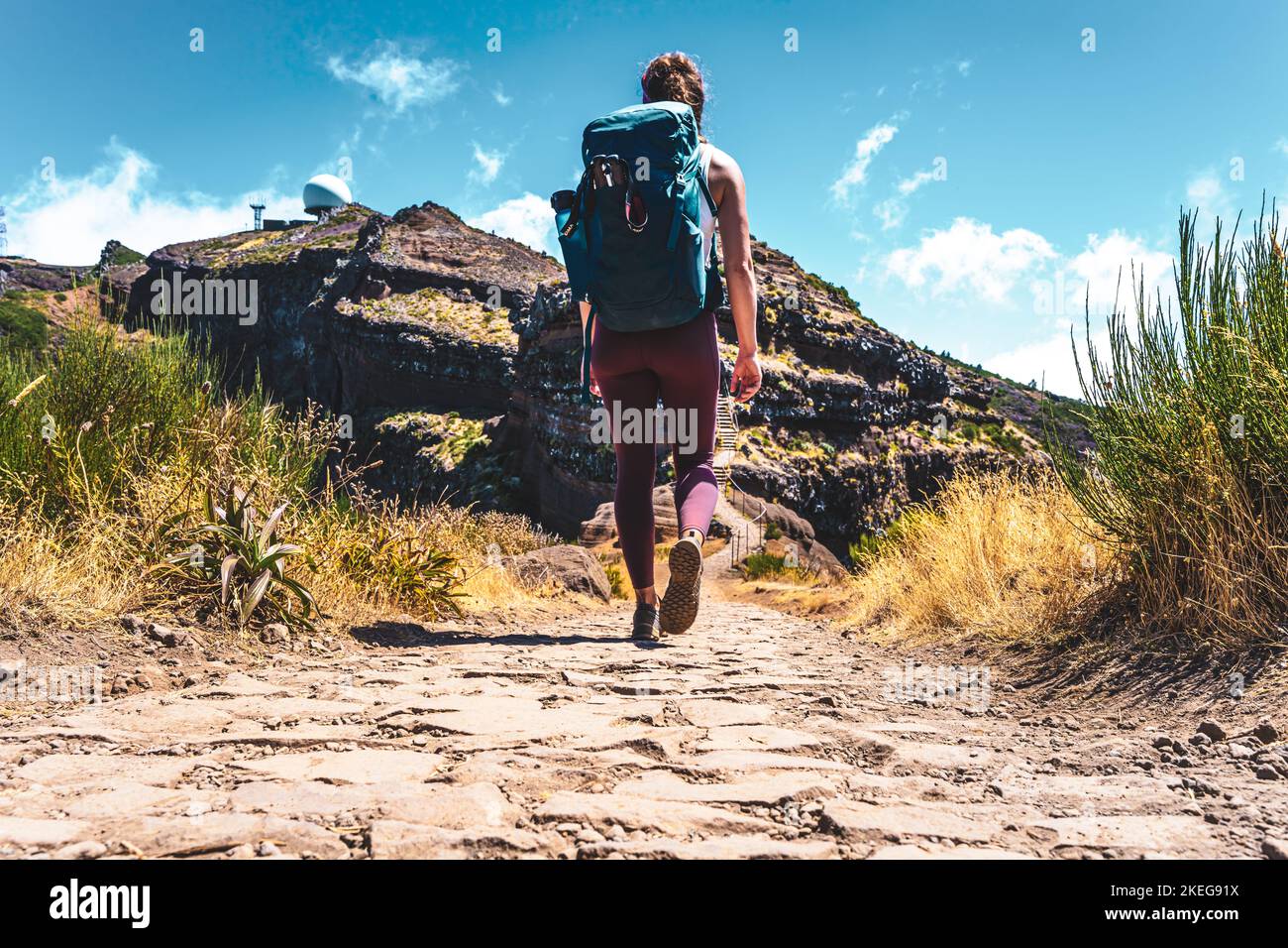 Description: Sportive woman with backpack walking along super scenic ...