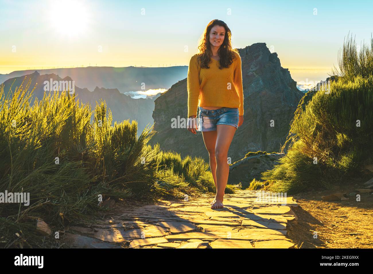 Description: Sporty woman walking barefoot in the evening sun on Pico ...