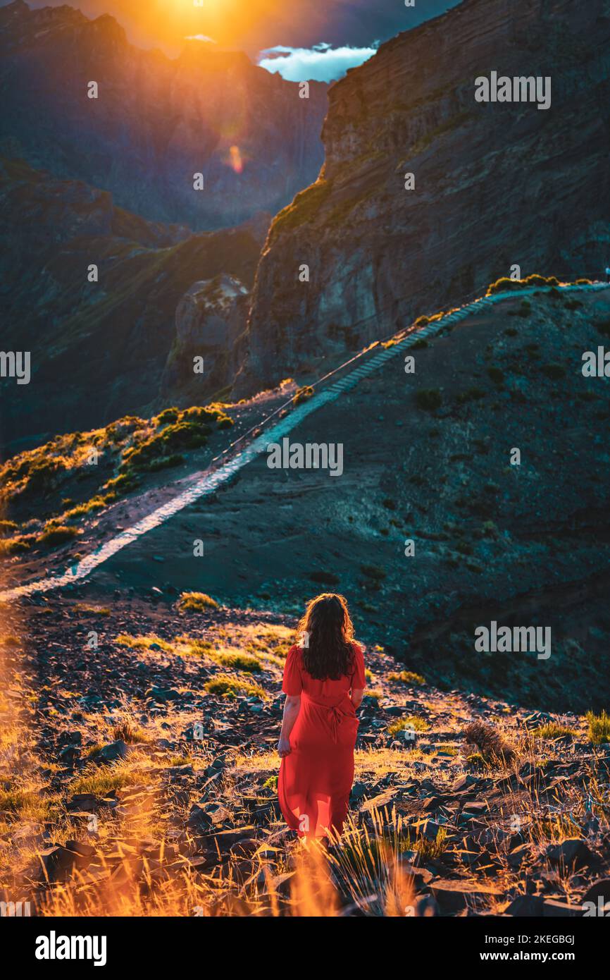 Description: Beautiful woman in red dress enjoying sunny evening ...