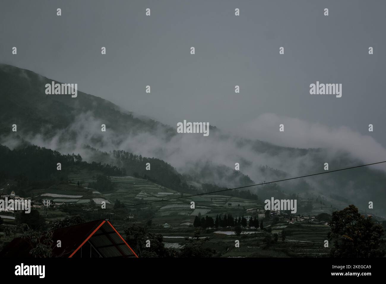 A view of Mount Merapi in Indonesia, covered in smoke behind the houses ...