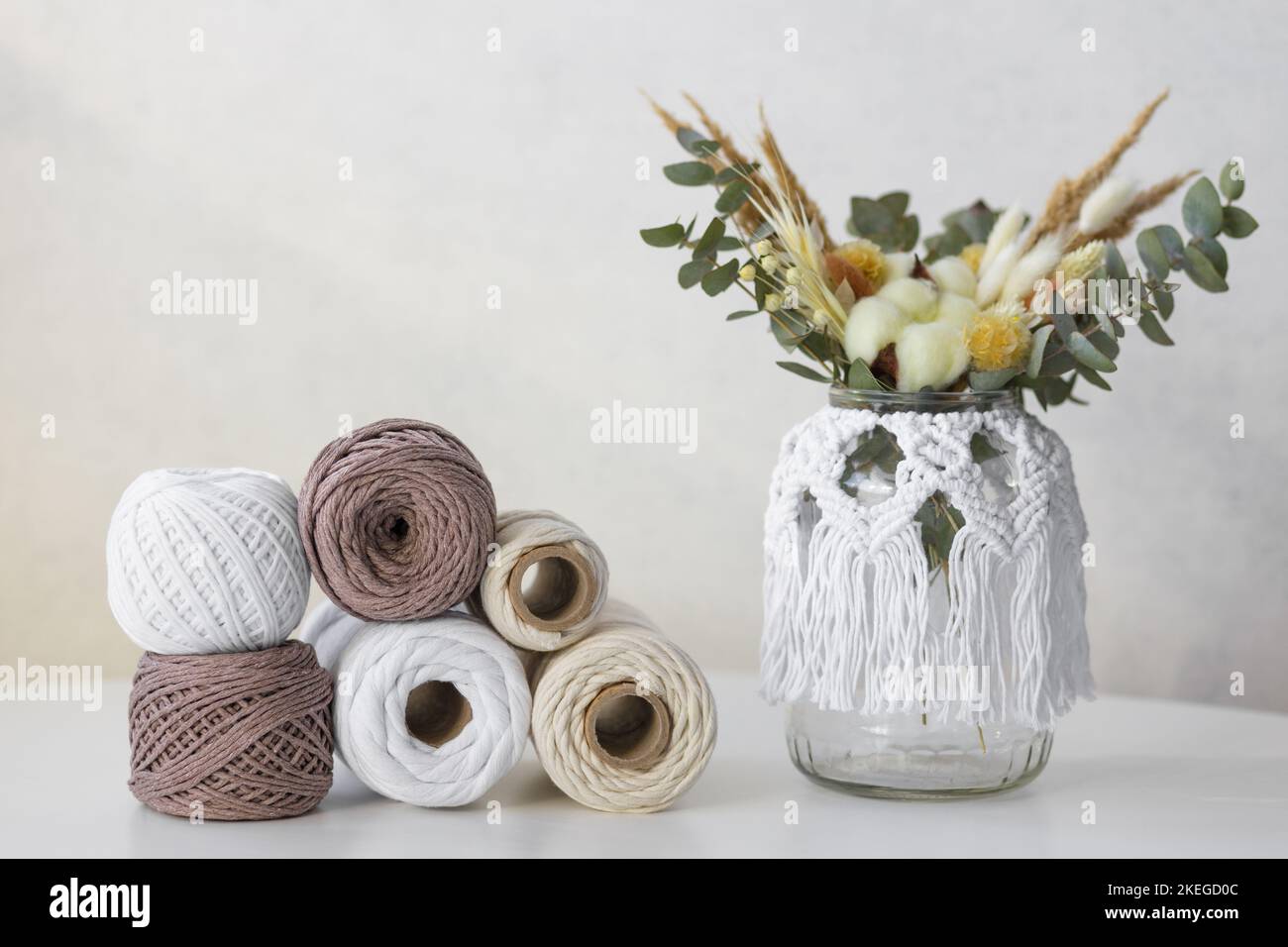 A composition with balls for knitting and a jar with dried flowers ...