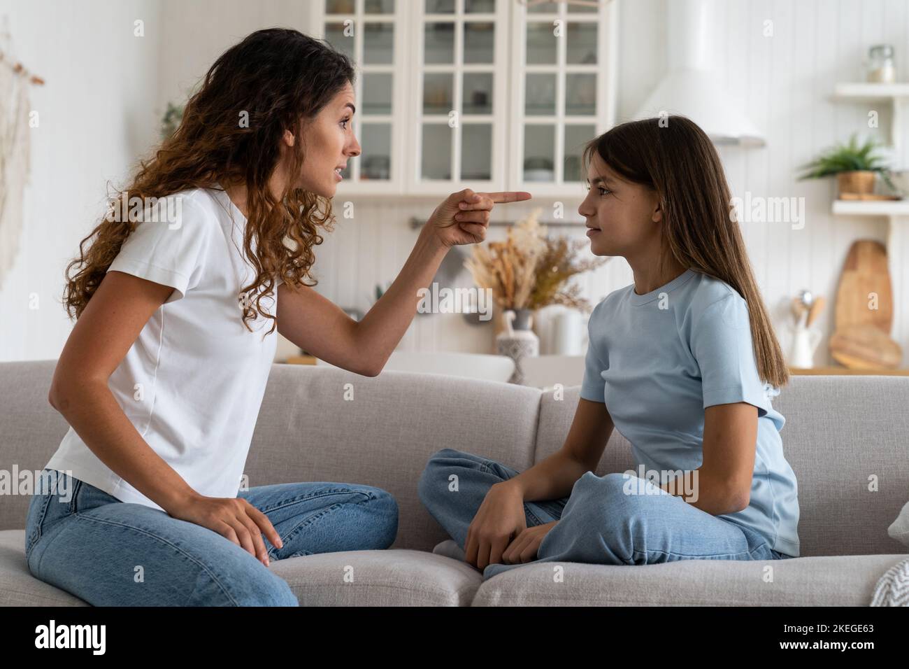 Nervous Caucasian woman looks with anger at guilty daughter who does ...
