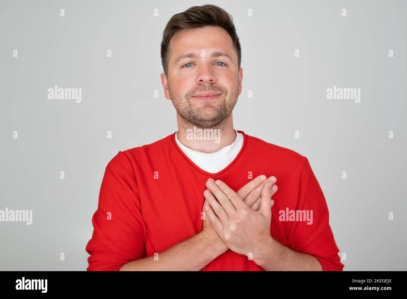 Happy man smiling while holding hands on his chest Stock Photo - Alamy