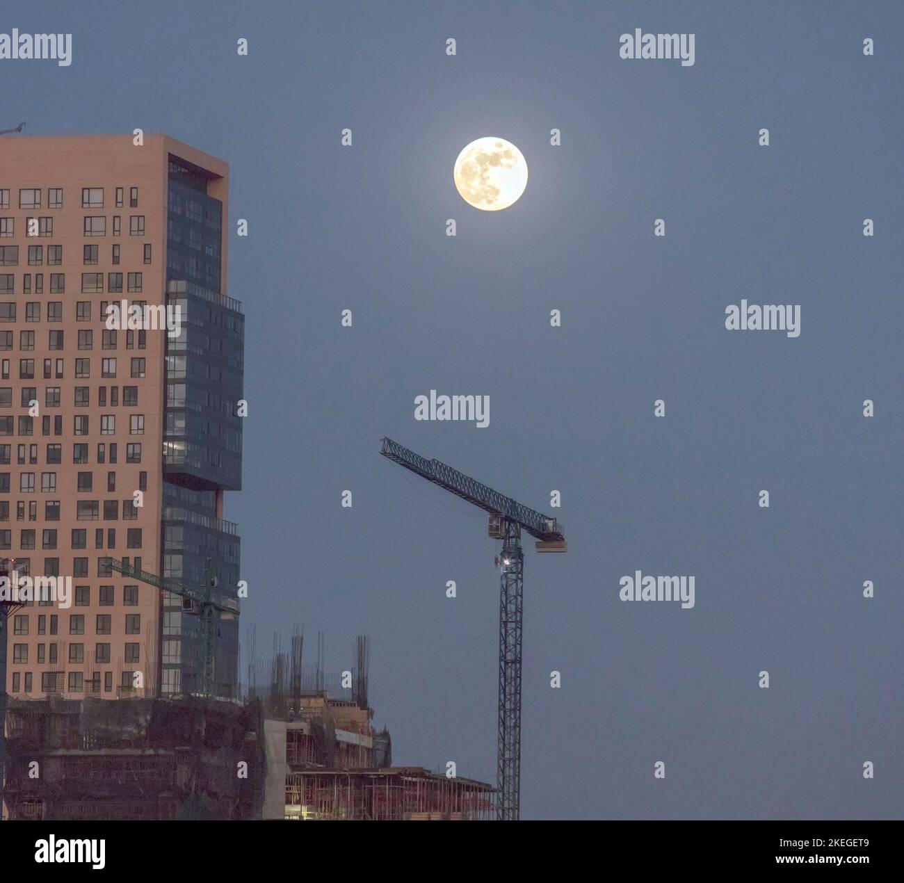 Full moon rises over a building construction crane Stock Photo - Alamy
