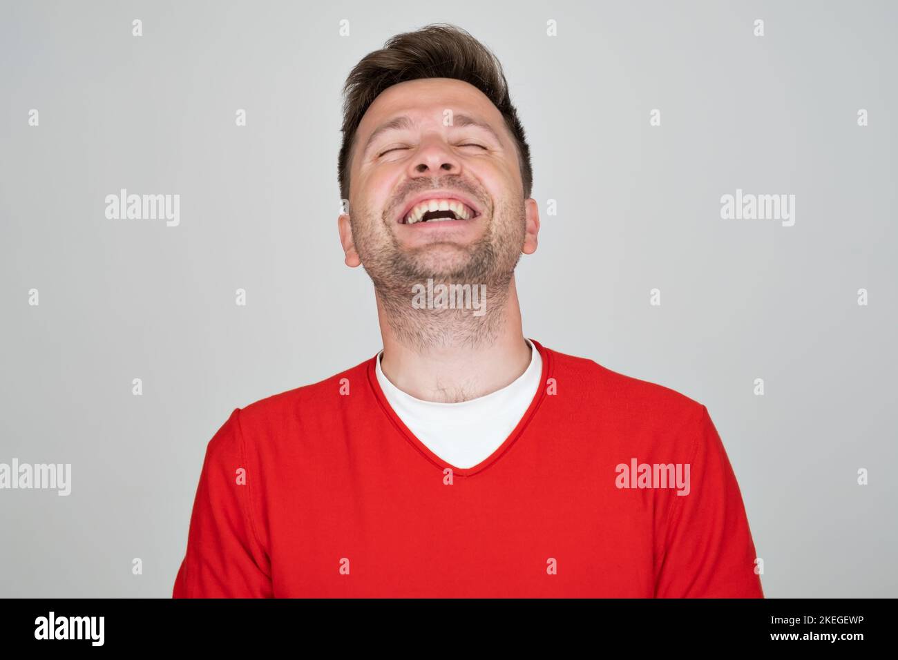 Handsome young man smiling while standing isolated on white background ...