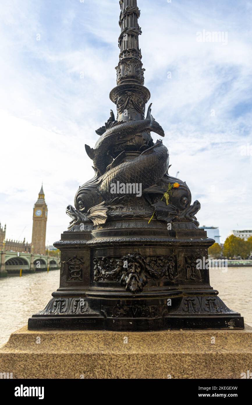 An intricate lampost in London with the Palace of Westminster and the ...