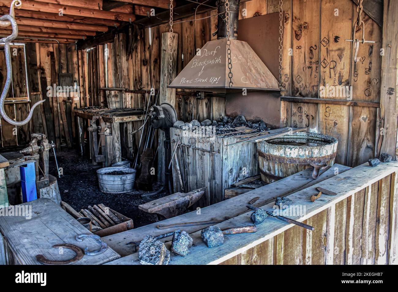 A blacksmith's workshop with a rusty chimney hood written on it "deaf ...