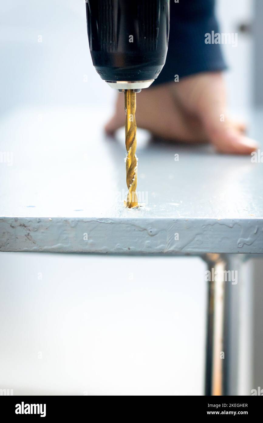 Drilling a hole aws a DIY project through a horizontal piece of wood ...