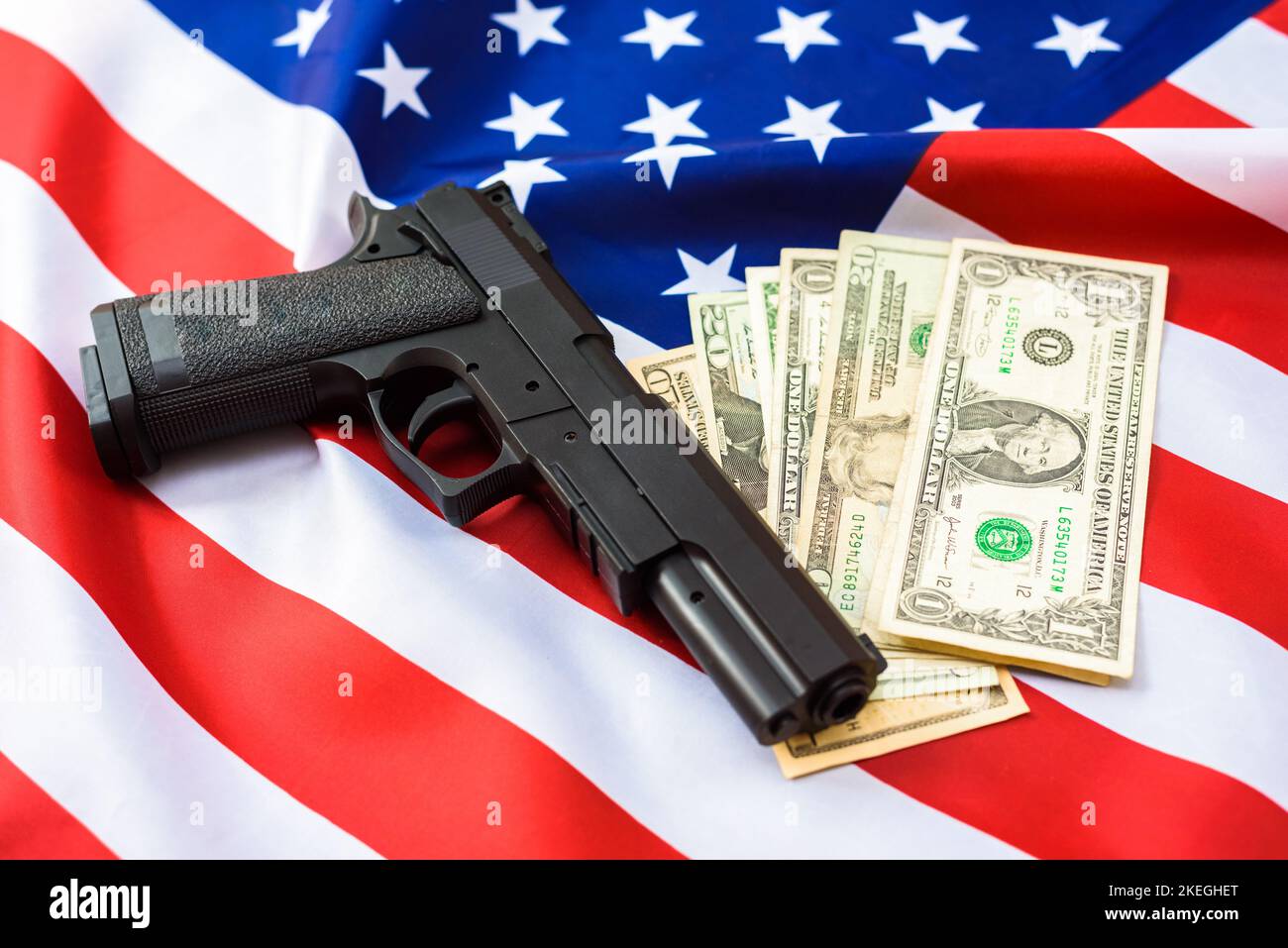 Gun over American flag with dollar bills around it Stock Photo - Alamy