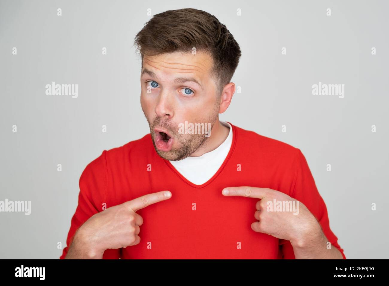 Indignant young man looks puzzled points at himself feels displeased ...