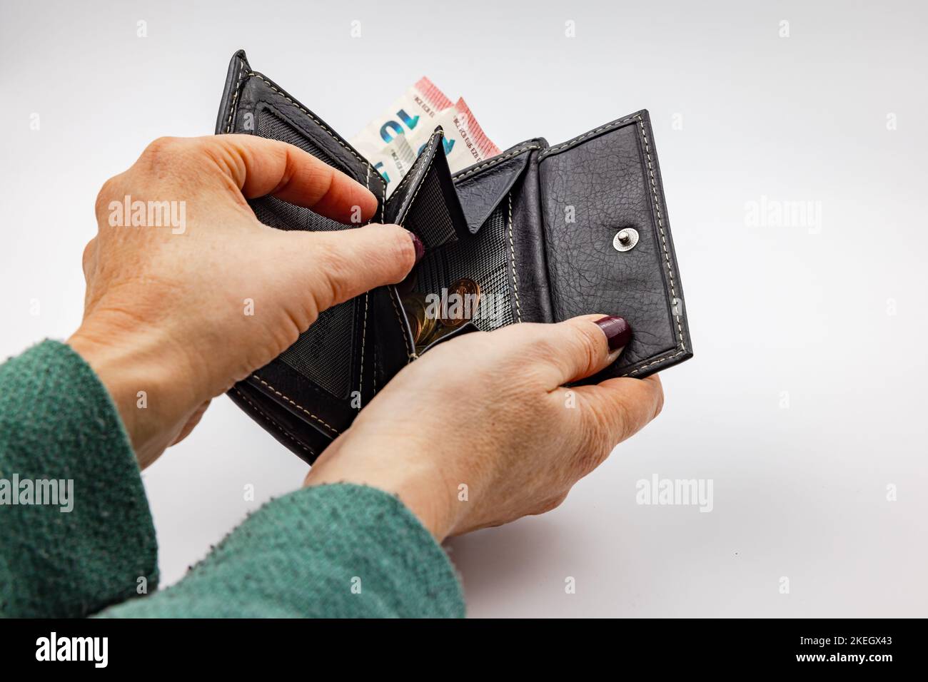 Purse with little euro coins and change and bills held by two hands as ...
