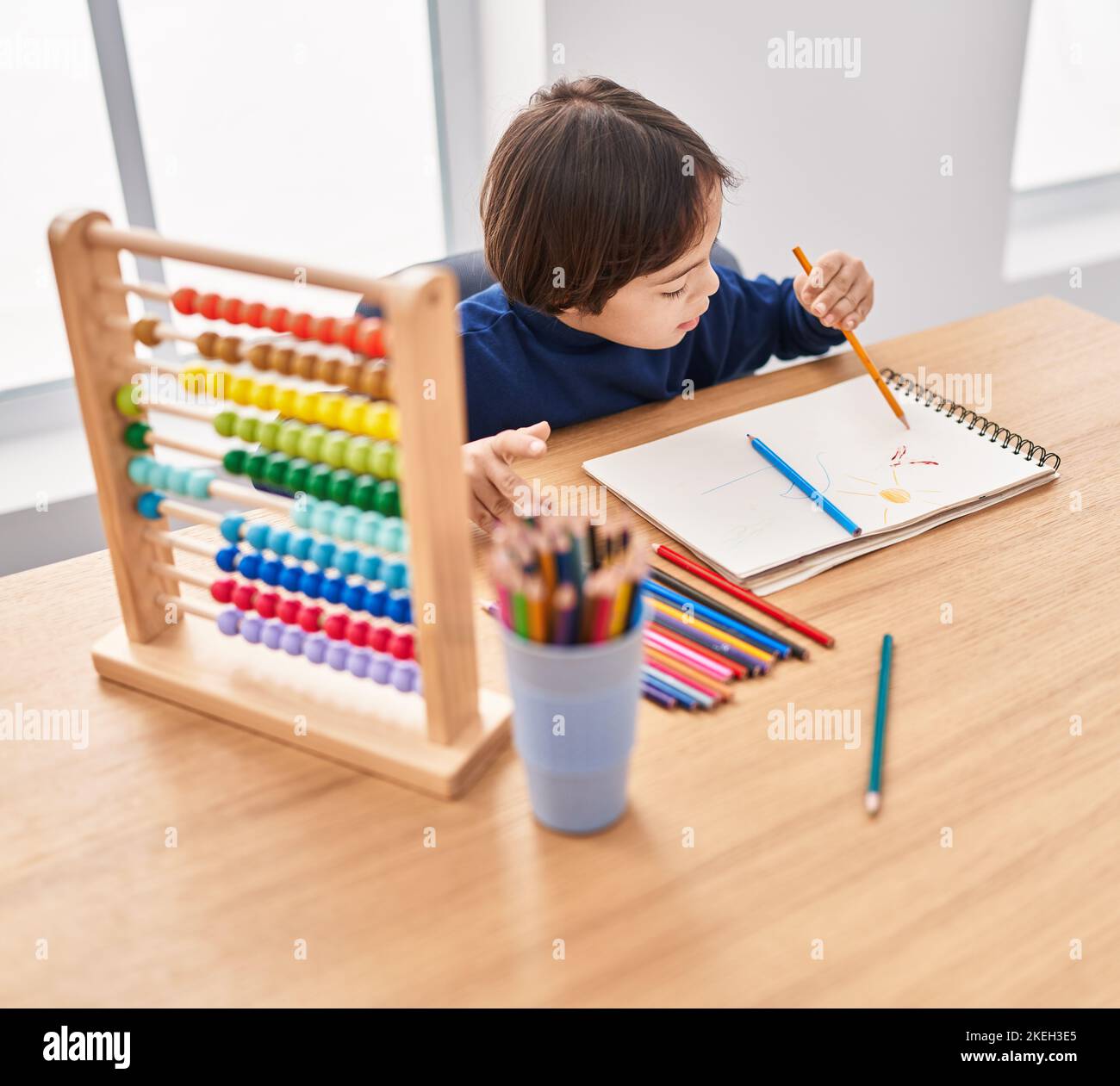 Down syndrome kid drawing on notebook at school Stock Photo - Alamy