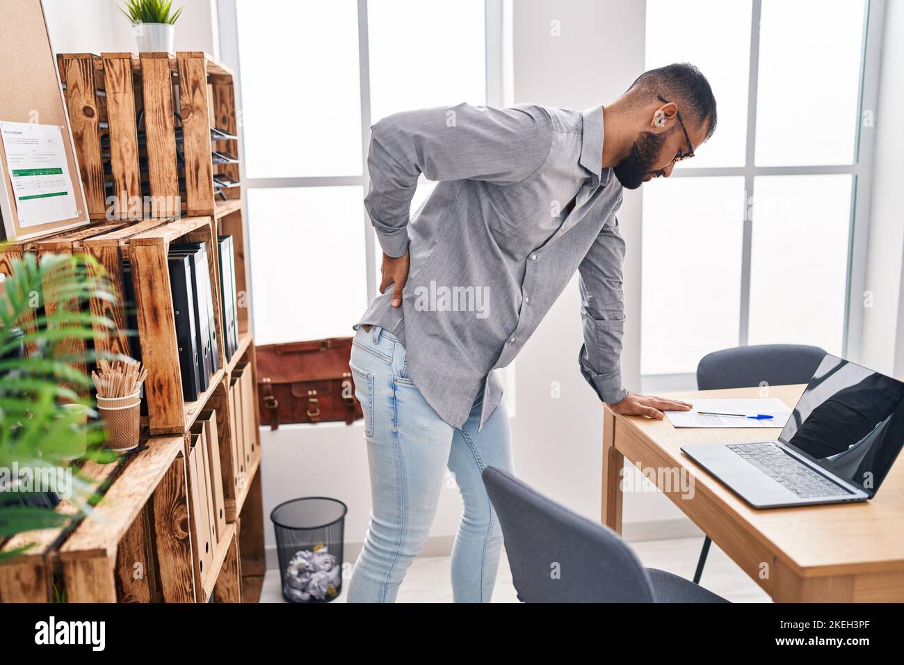 Young hispanic man business worker suffering for backache at office ...