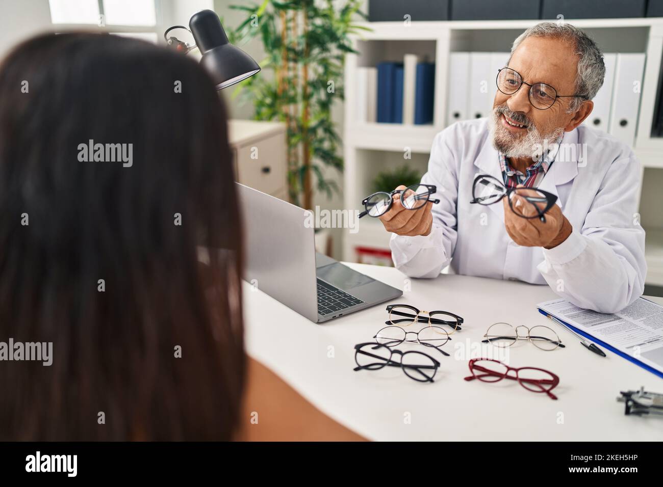 Optician showing eyeglasses elderly hi-res stock photography and images ...