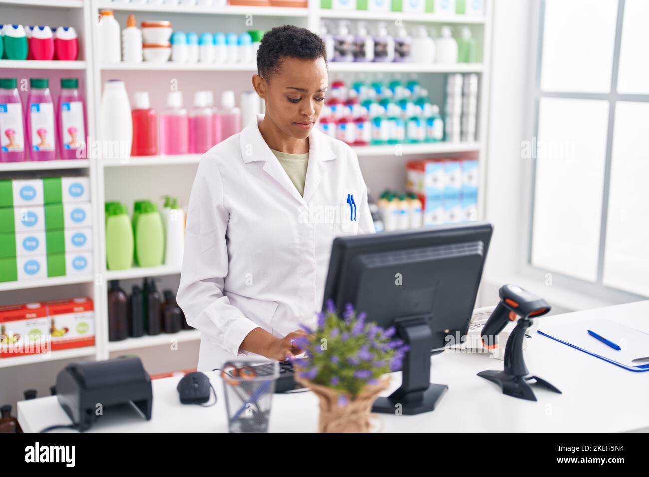 African american woman pharmacist using computer at pharmacy Stock ...