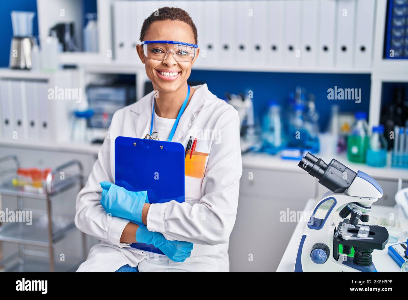 African american woman scientist smiling confident holding clipboard at laboratory Stock Photo ...