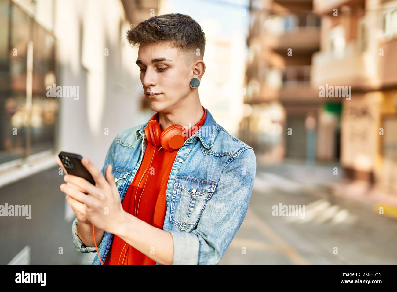 Young caucasian guy smiling using smartphone at the city Stock Photo ...