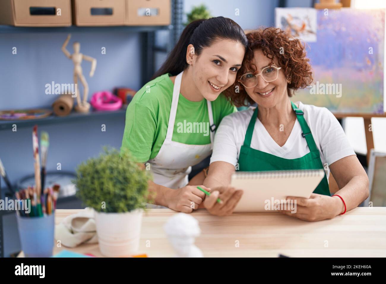 Two women artists drawing on notebook at art studio Stock Photo - Alamy