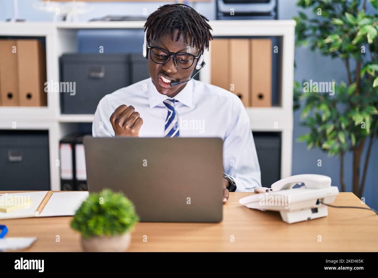 African man with dreadlocks wearing call center agent headset annoyed ...