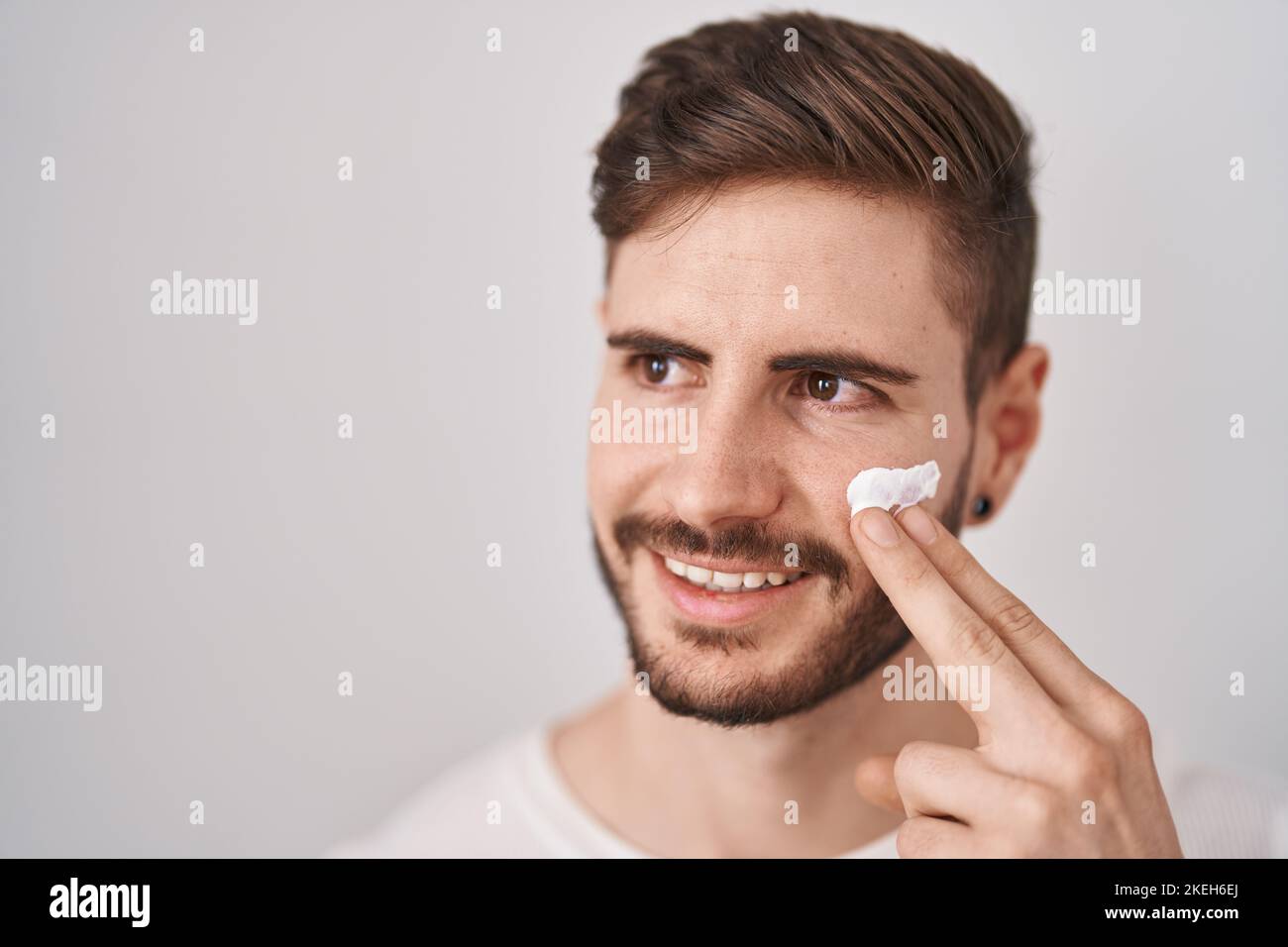 Hispanic Man With Beard Using Moisturizer Facial Cream Smiling Looking