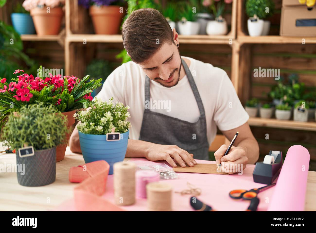 Young caucasian man florist smiling confident writing on envelope ...