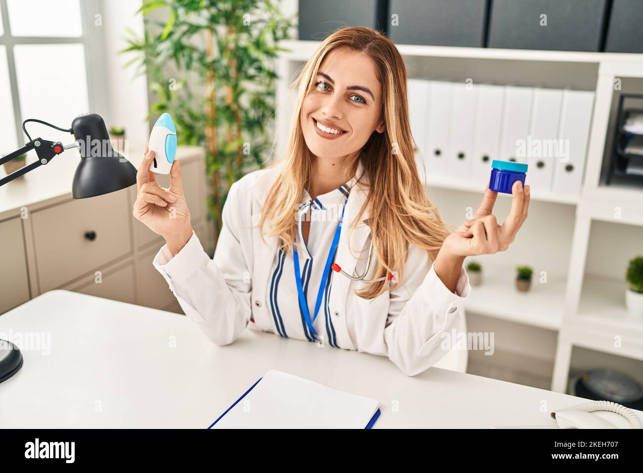 Young blonde doctor woman holding medicine products to breath better ...