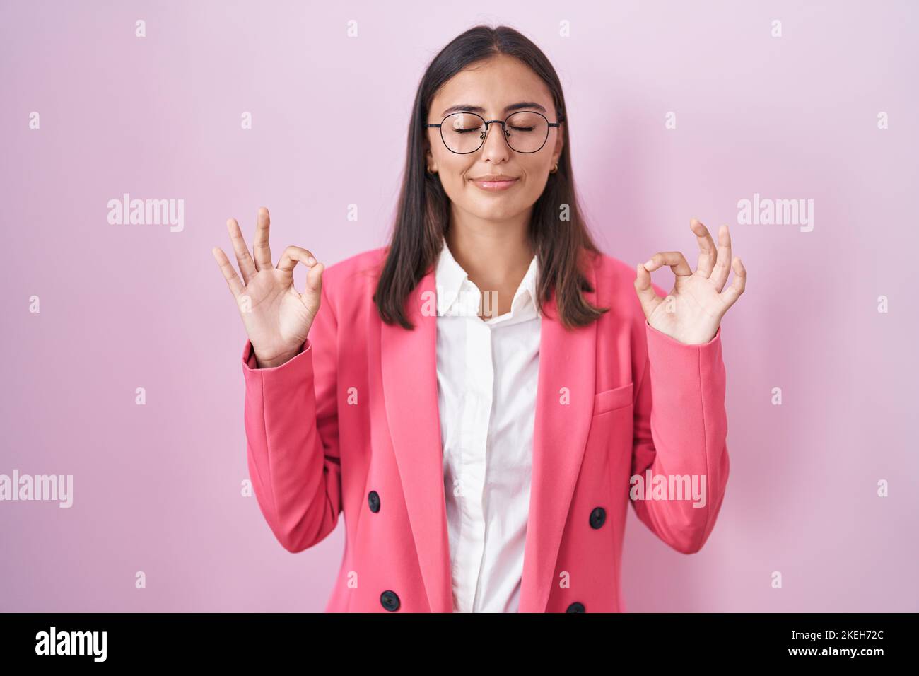 Young hispanic woman wearing business clothes and glasses relaxed and ...
