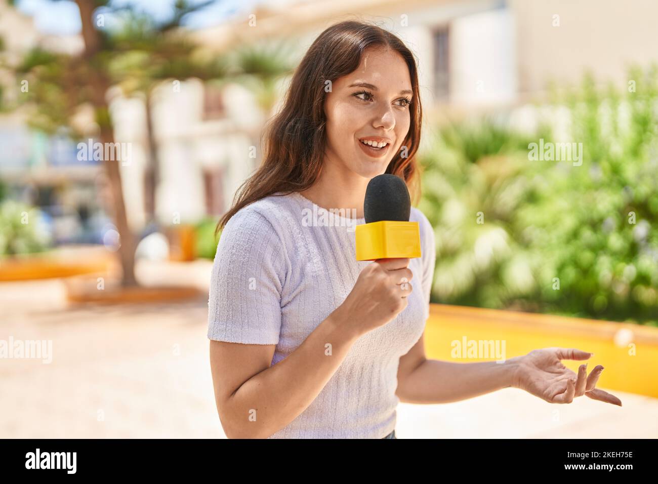 Young woman reporter working using microphone at park Stock Photo - Alamy