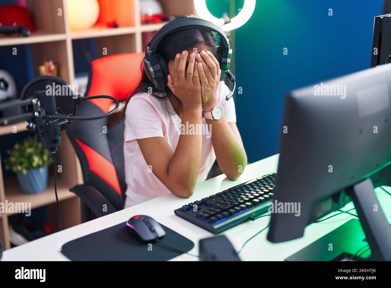Young beautiful hispanic woman streamer stressed using computer at ...