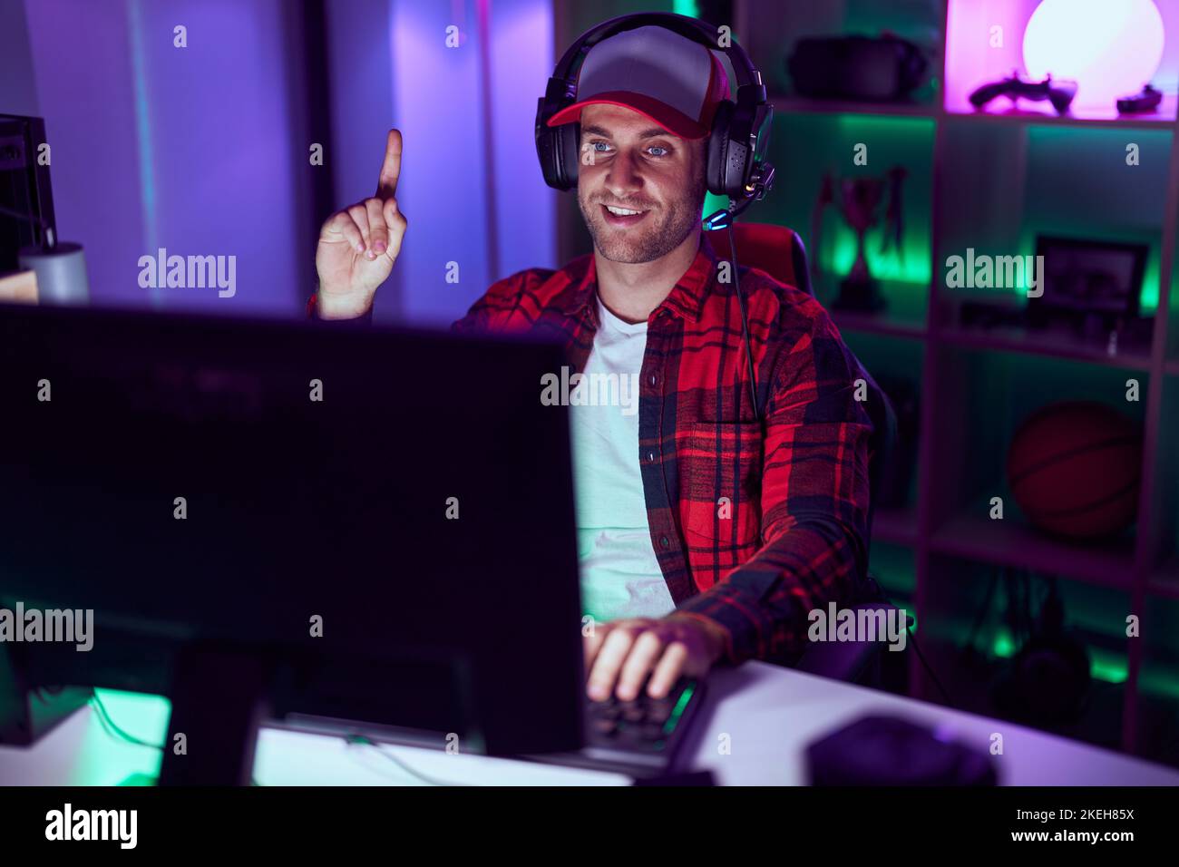 Young caucasian man playing video games surprised with an idea or ...