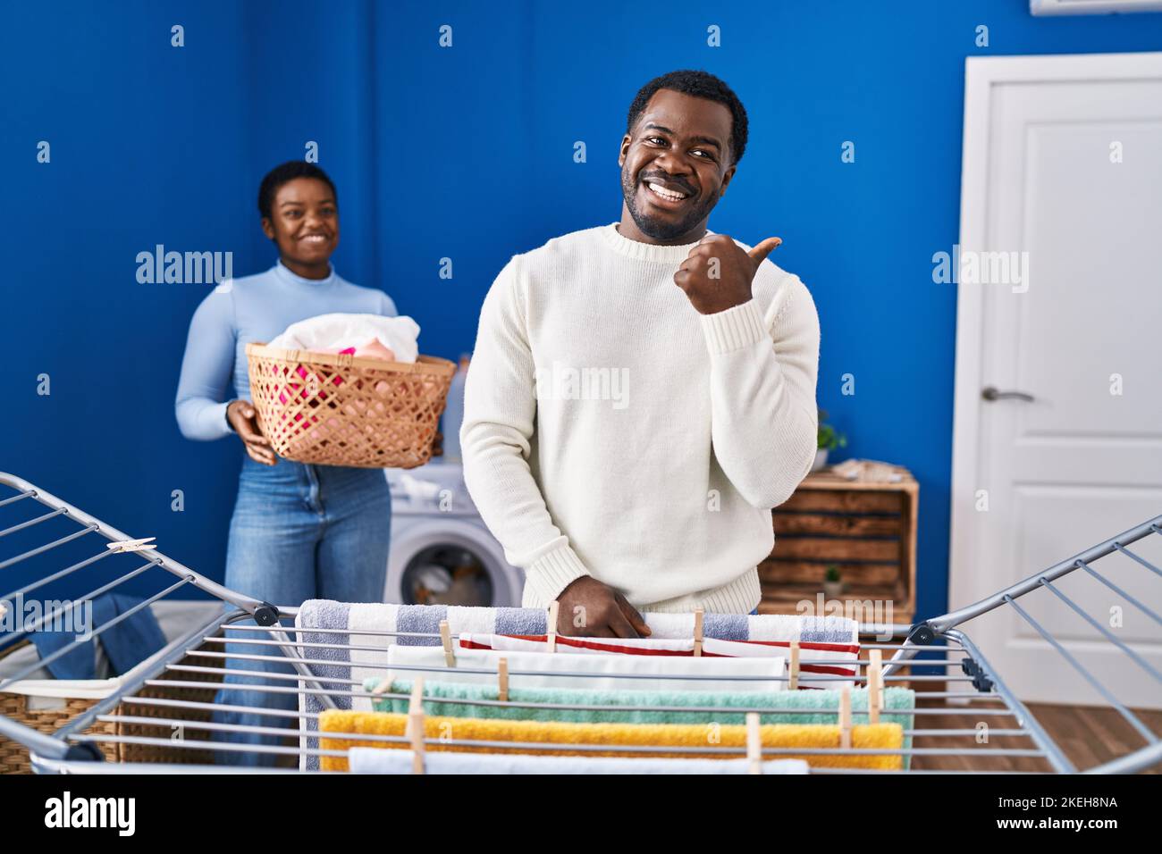 Young african american couple hanging clothes at clothesline smiling ...