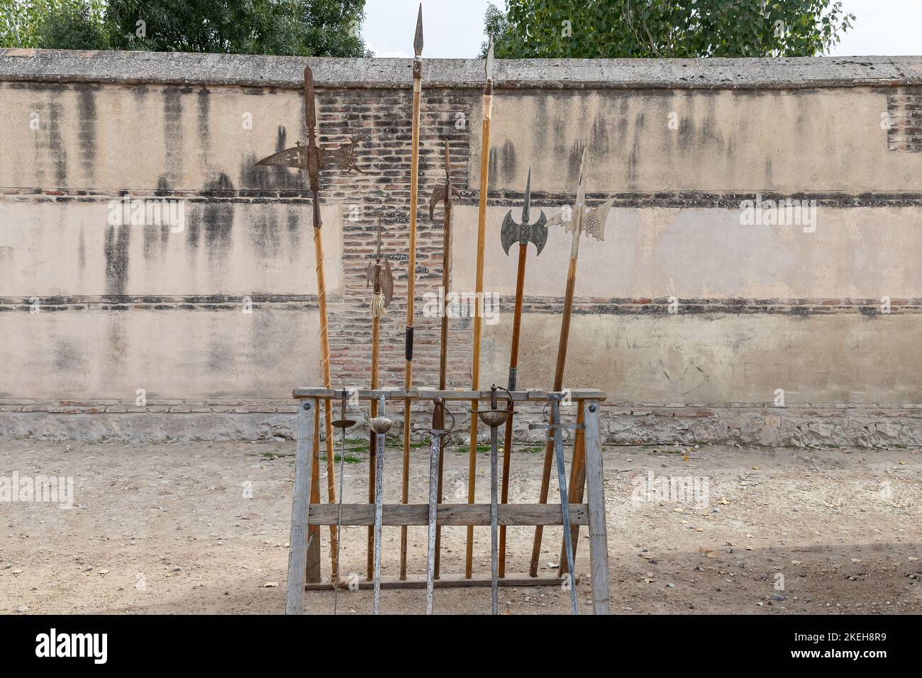 outdoor scene of an exhibitor with several medieval spears, halberds ...