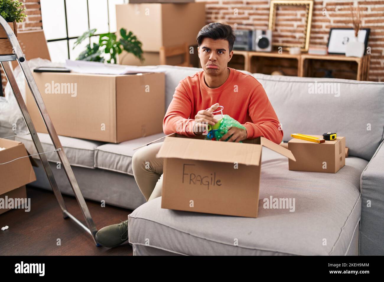 Hispanic man moving to a new home unpacking depressed and worry for ...