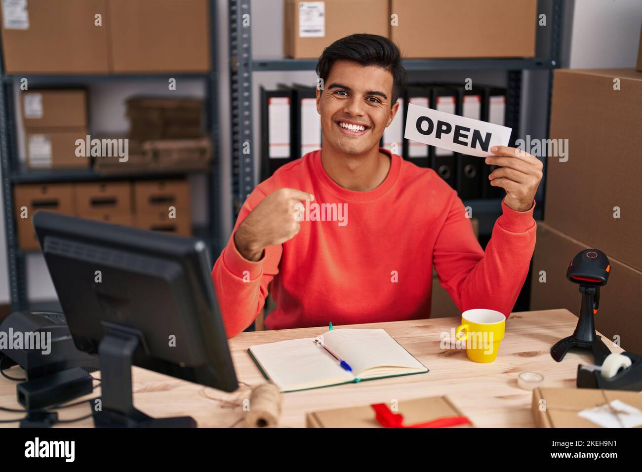 Hispanic man working at small business ecommerce holding open banner ...